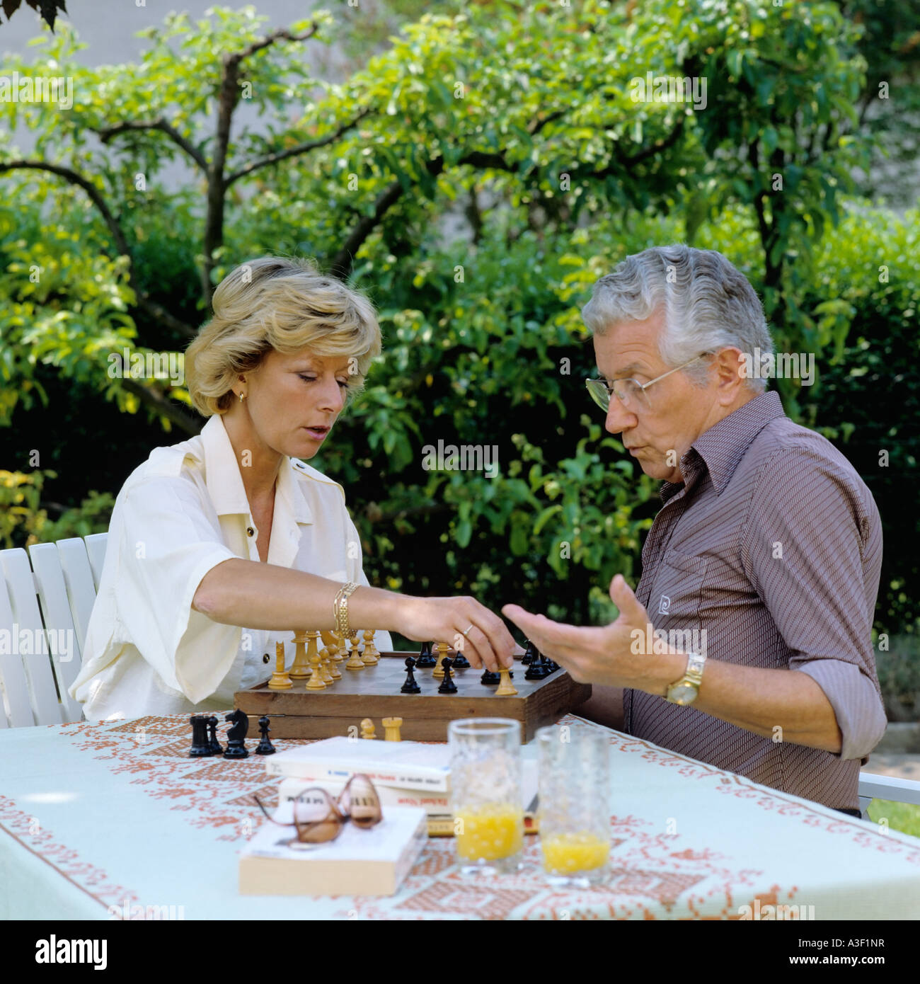 MR MATURE COUPLE PLAYING CHESS IN GARDEN Stock Photo - Alamy