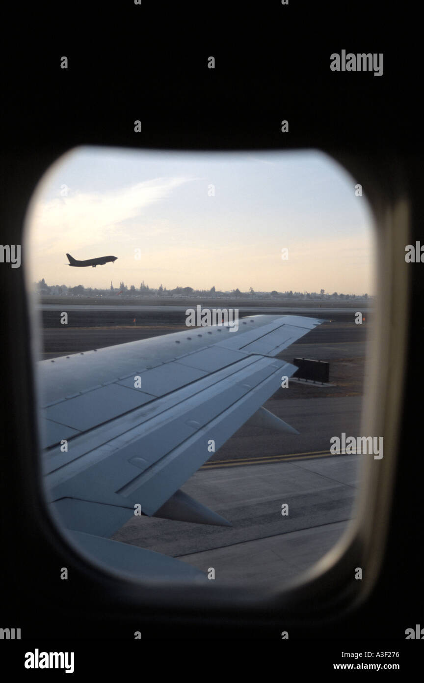 View of plane taking off through window of plane on ground United ...