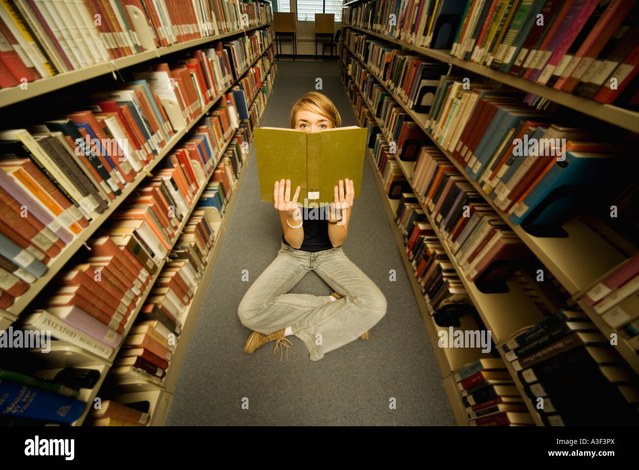 Student reading in a library Stock Photo - Alamy