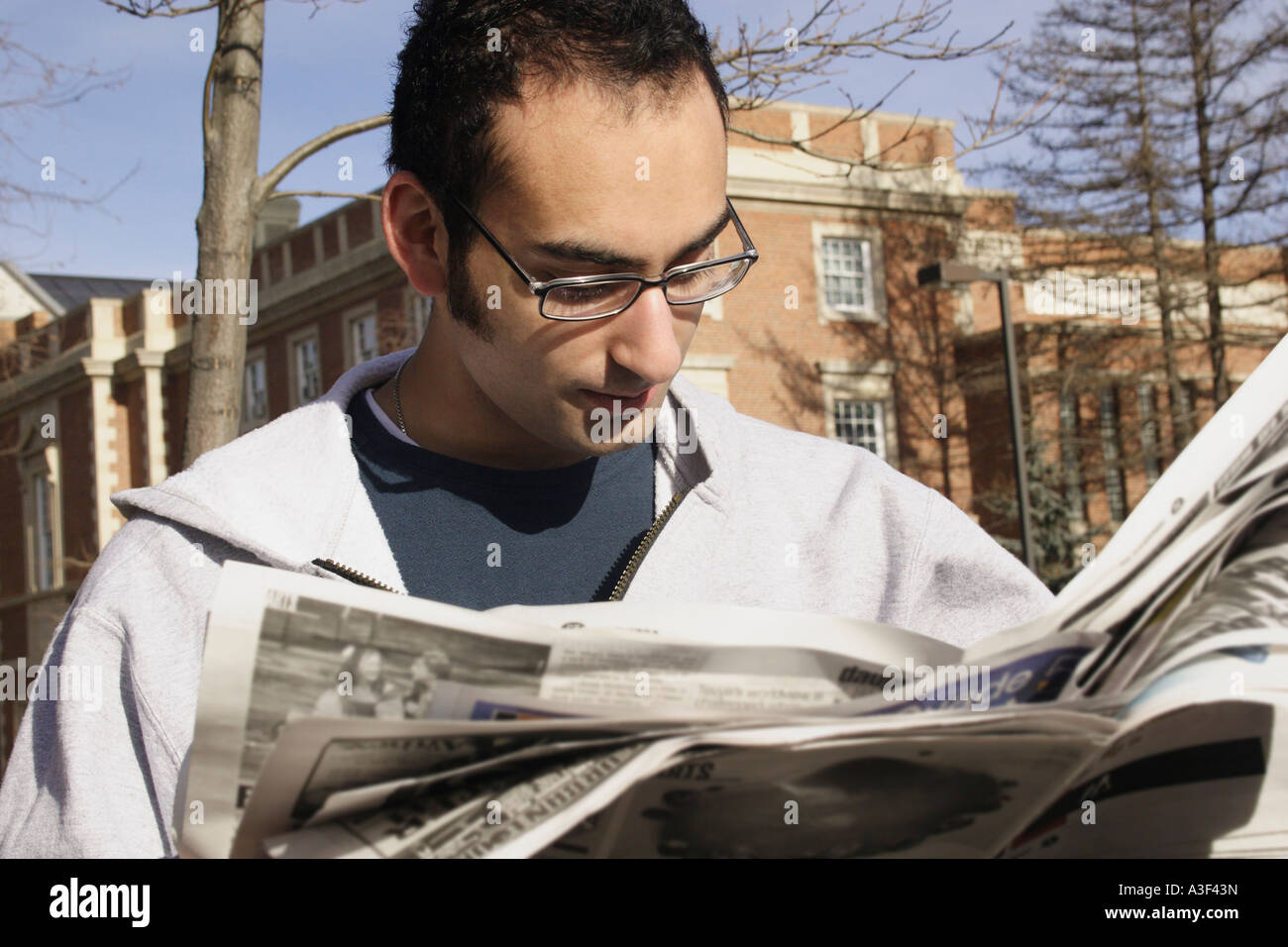 Young man reading newspaper outside Stock Photo - Alamy