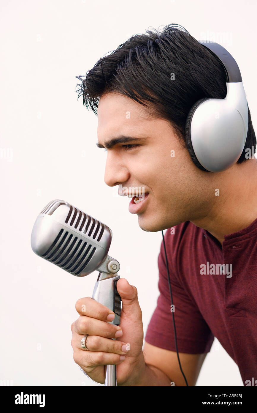 Close-up of a young man singing into a microphone Stock Photo - Alamy