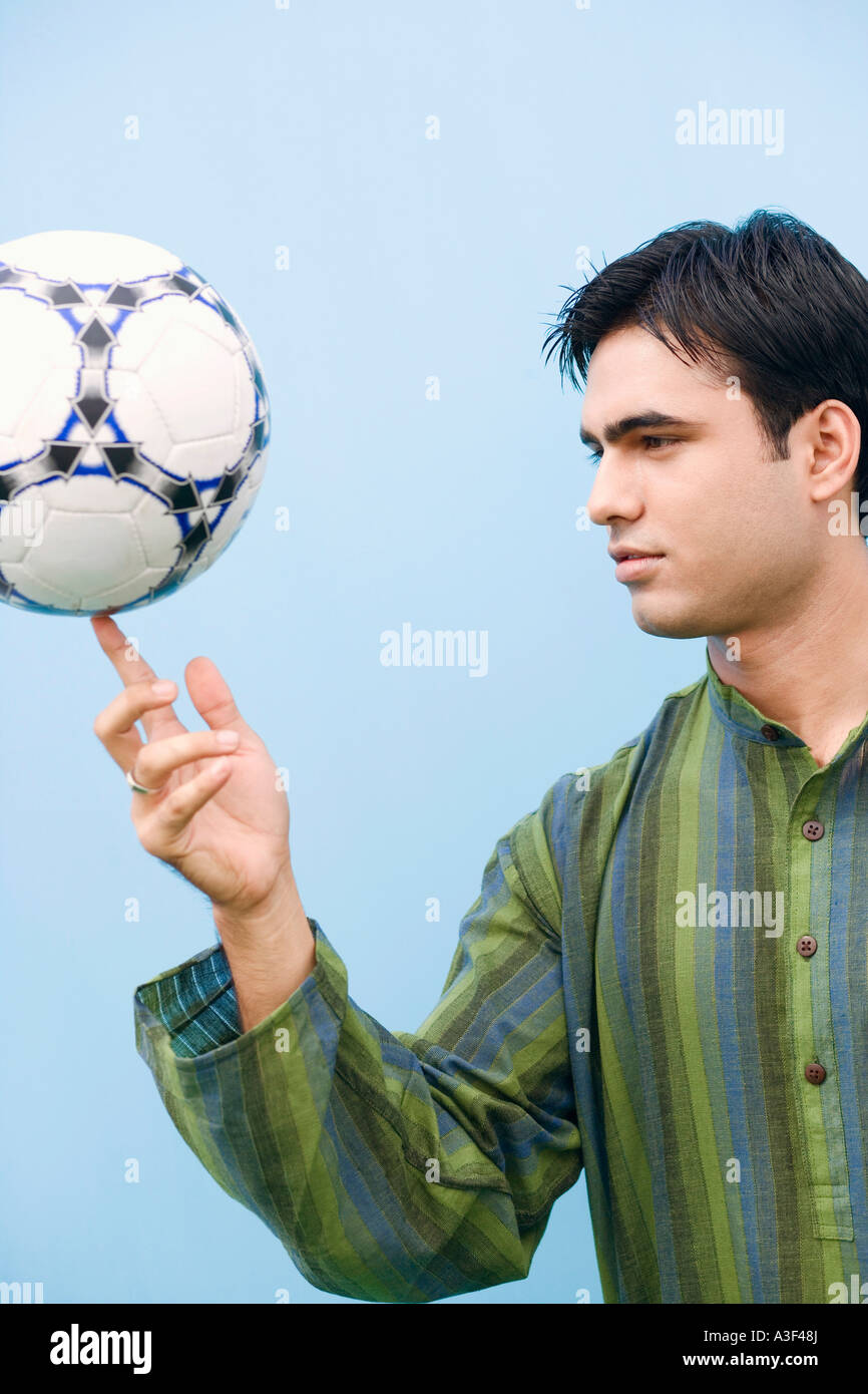 Young man balancing a soccer ball on his finger Stock Photo - Alamy