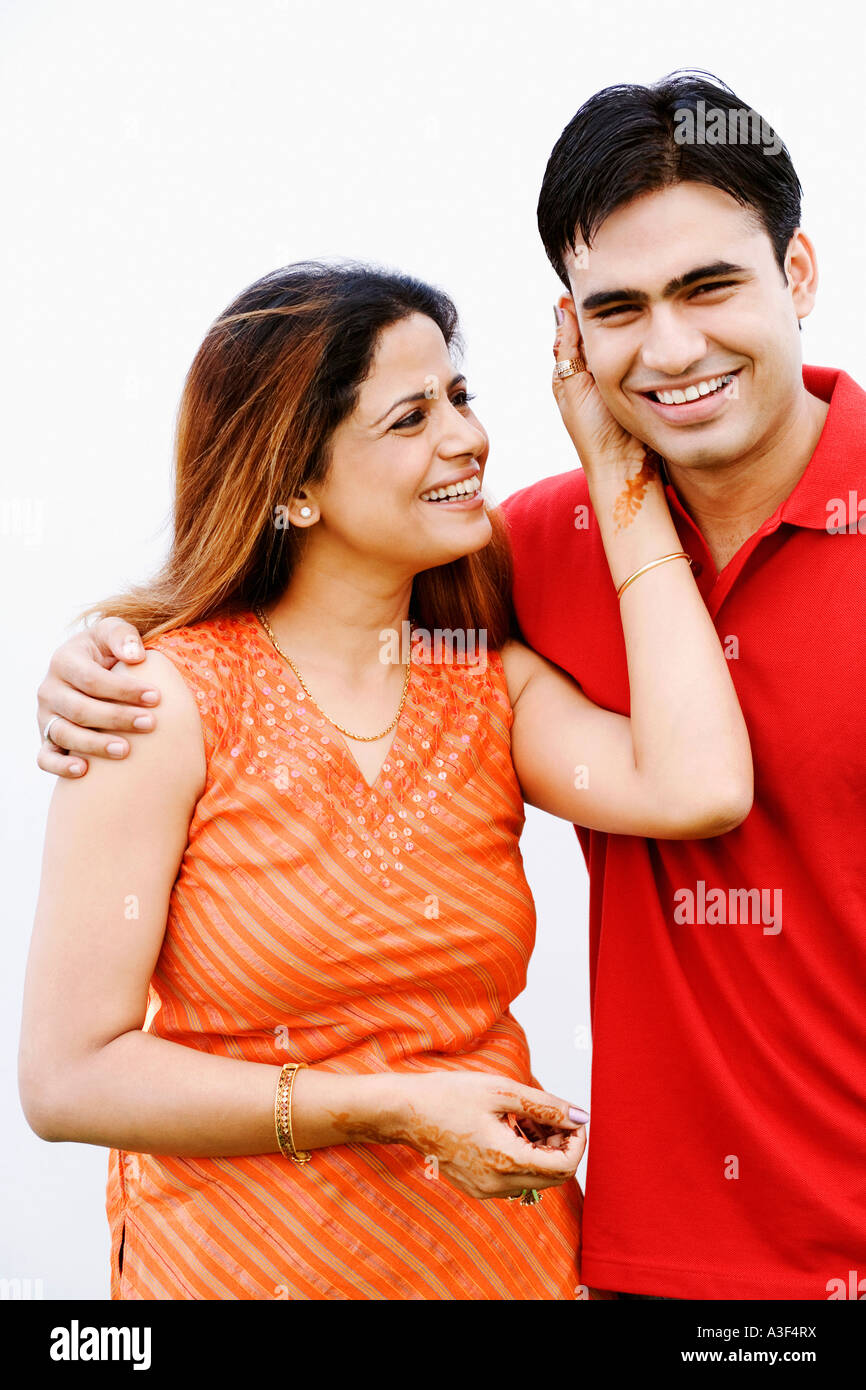 Portrait of a young woman pulling the ear of a mid adult man and ...