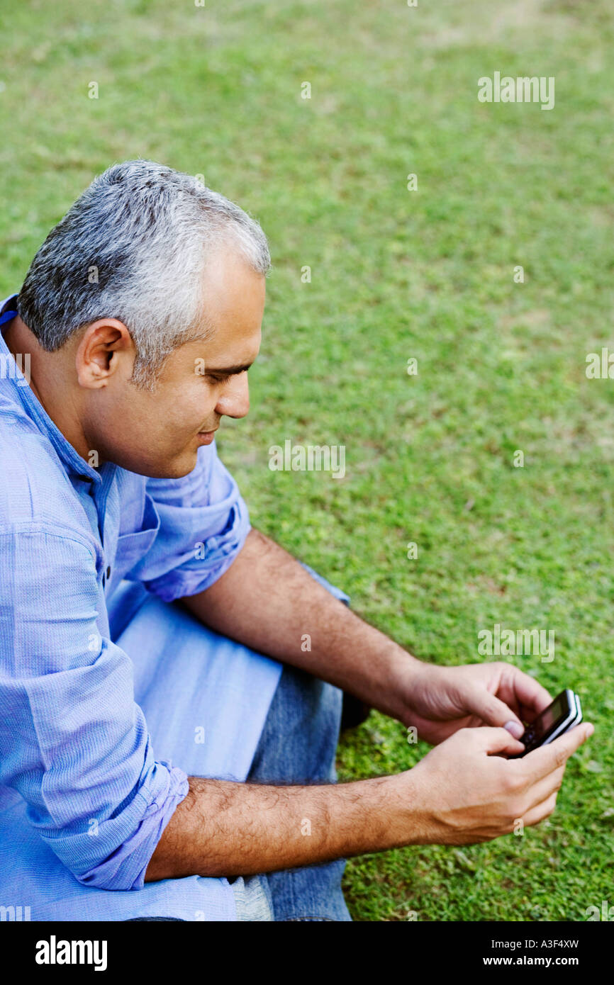 Side profile of a mid adult man operating a mobile phone Stock Photo ...