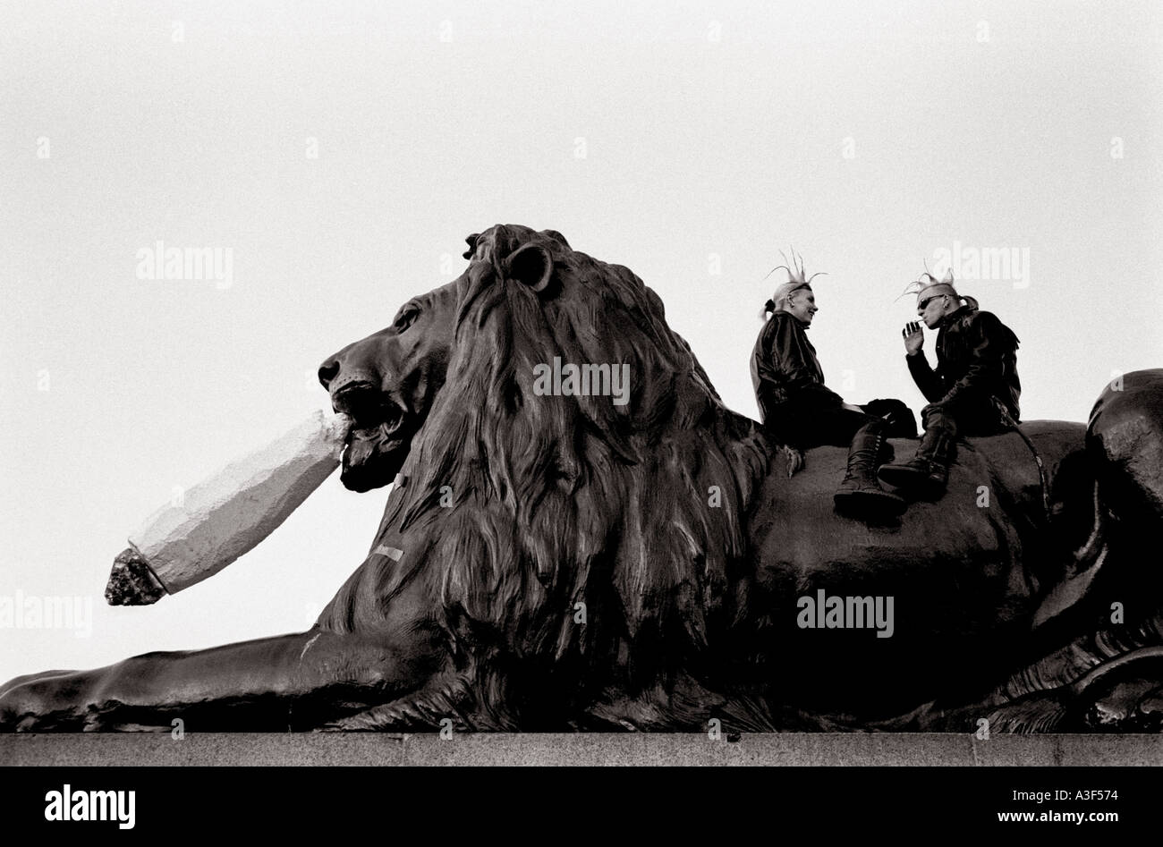 Couple having a joint on top of lion in Trafalgar Square during a rally ...