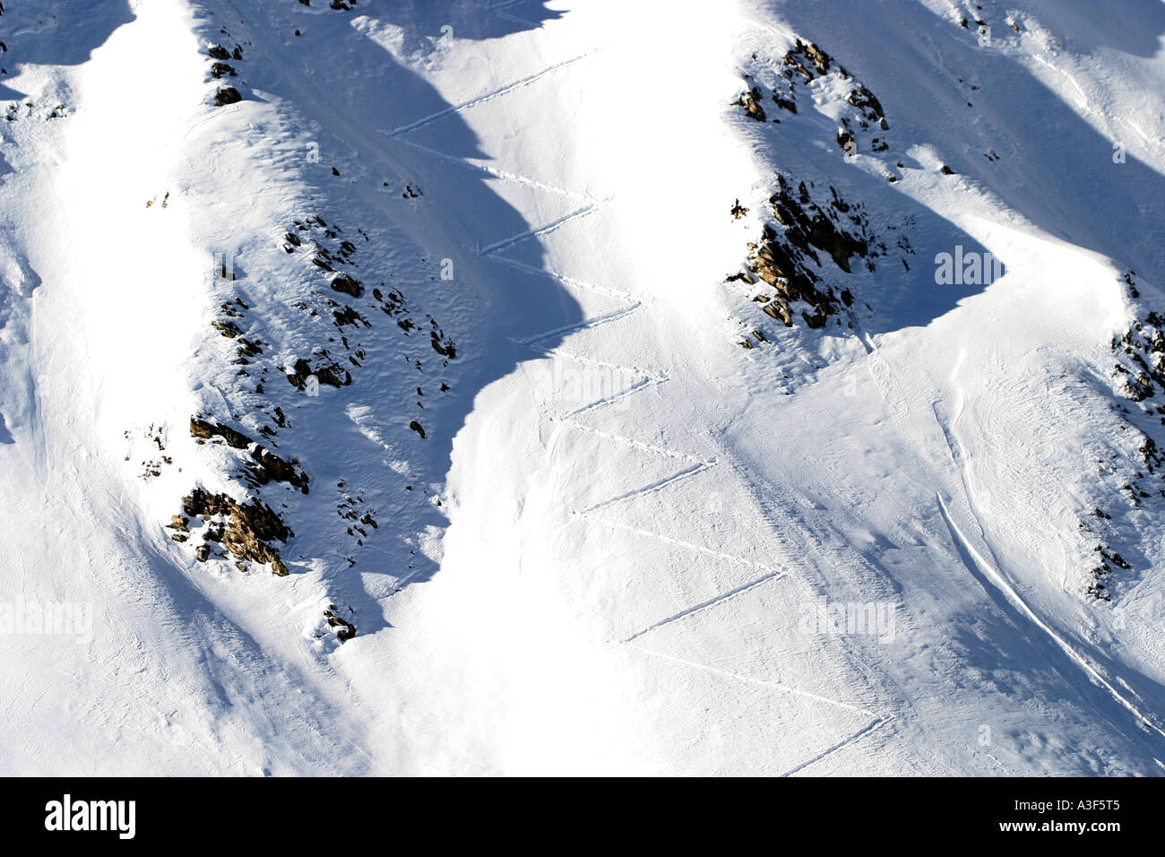 Man made tracks up steep alpine slope Stock Photo - Alamy