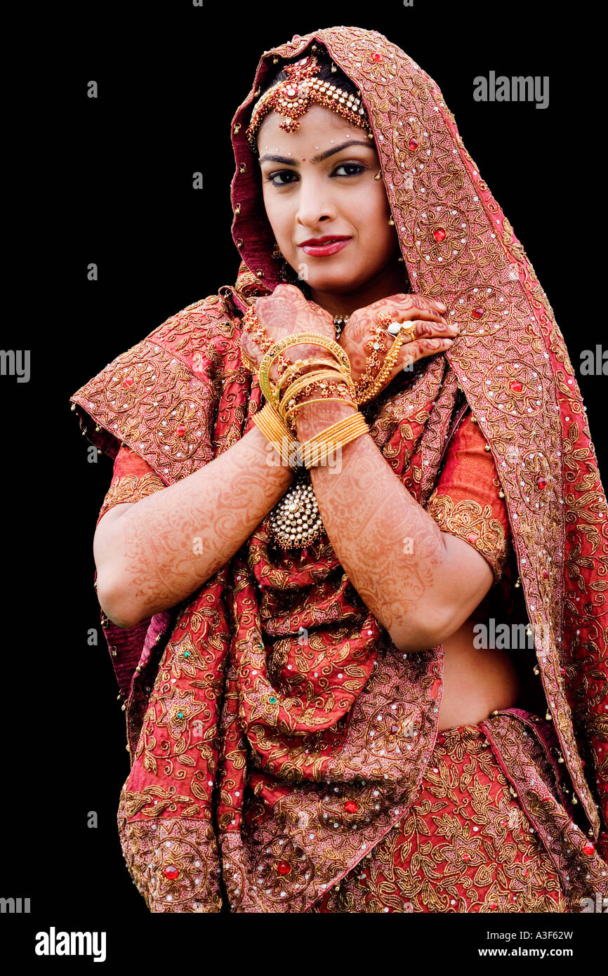 Portrait of a bride in a traditional wedding dress standing with her ...