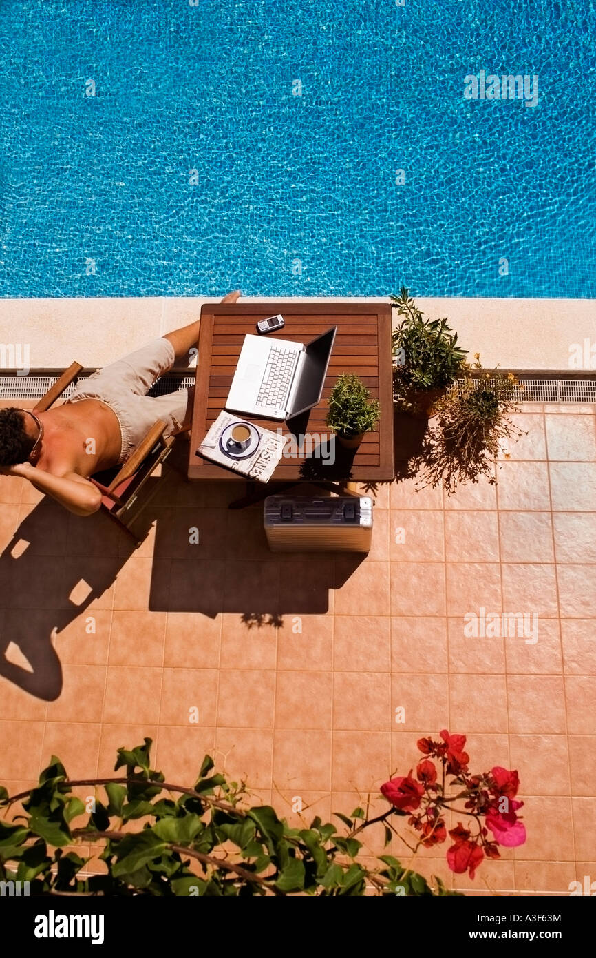 man with laptop by pool Stock Photo - Alamy
