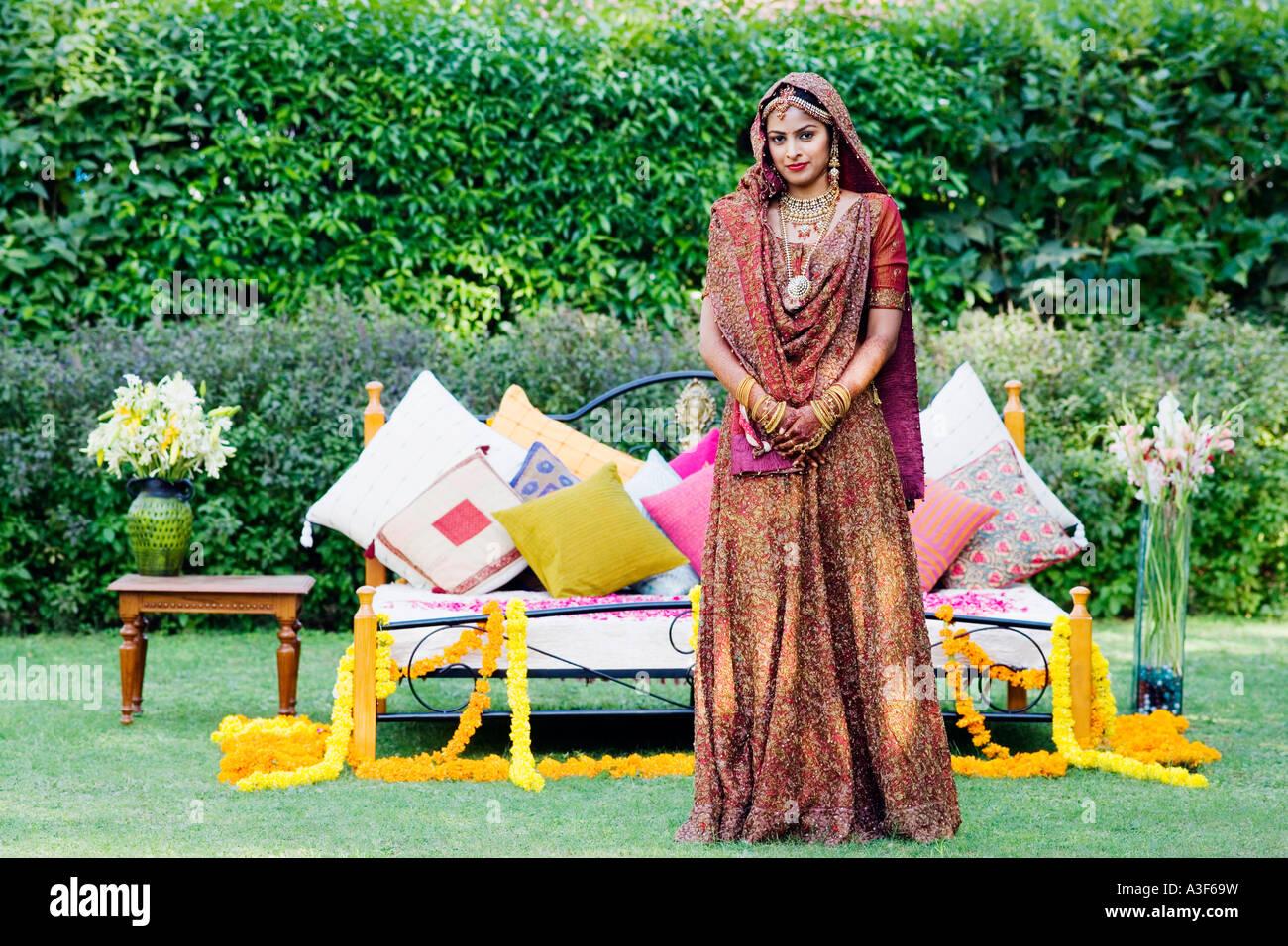 Portrait of a bride in a traditional wedding dress standing in front of ...