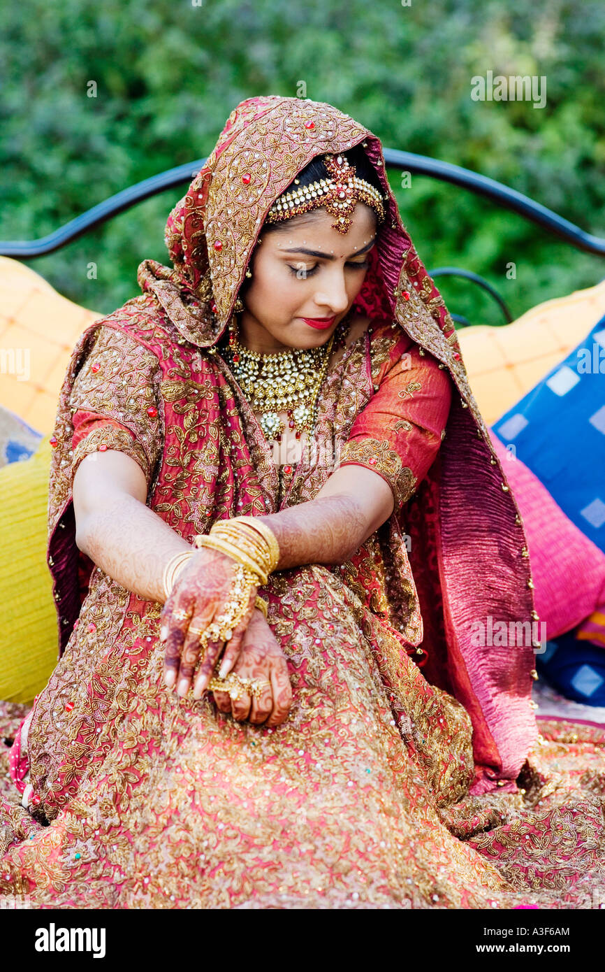 Bride in a traditional wedding dress sitting on the bed in a lawn Stock ...