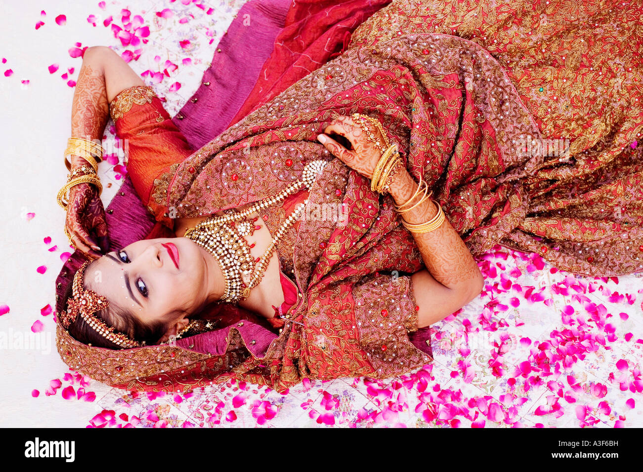 High angle view of a bride in a traditional wedding dress lying on the ...