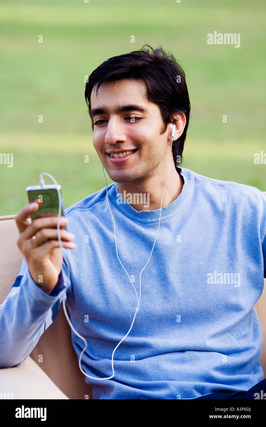Young man listening to an MP3 player Stock Photo - Alamy