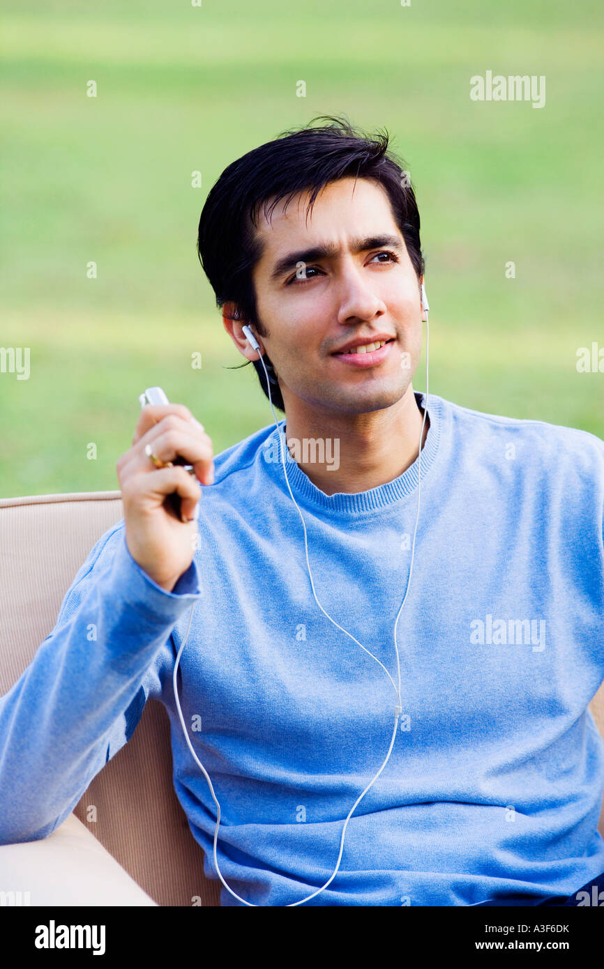 Young man listening to an MP3 player Stock Photo - Alamy