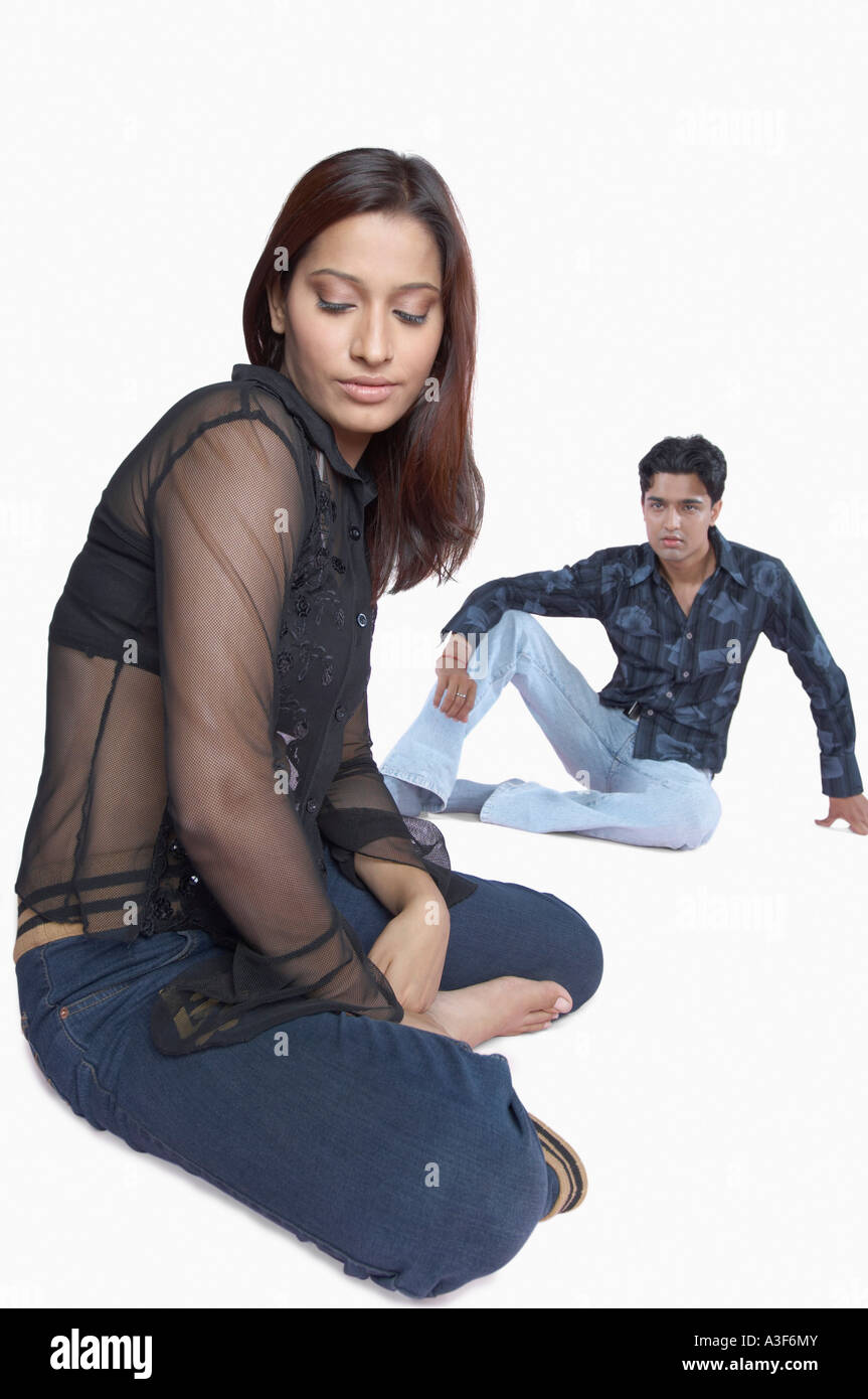 Side profile of a young woman sitting on the floor with a young man ...