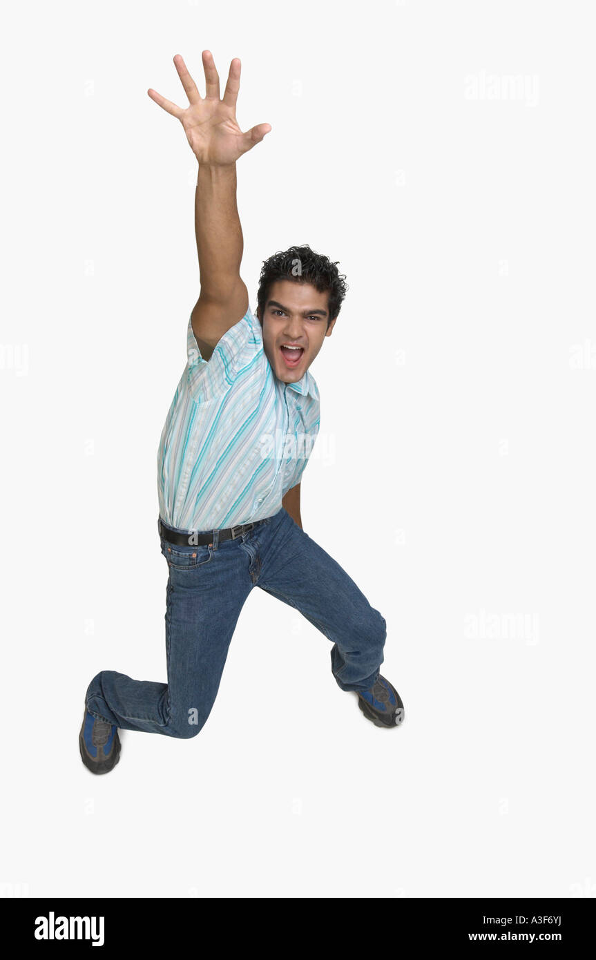 Portrait of a young man shouting with his hand raised Stock Photo - Alamy