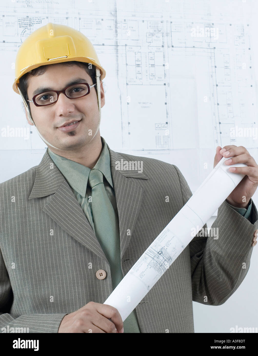 Portrait of an architect holding a blueprint and smiling Stock Photo ...