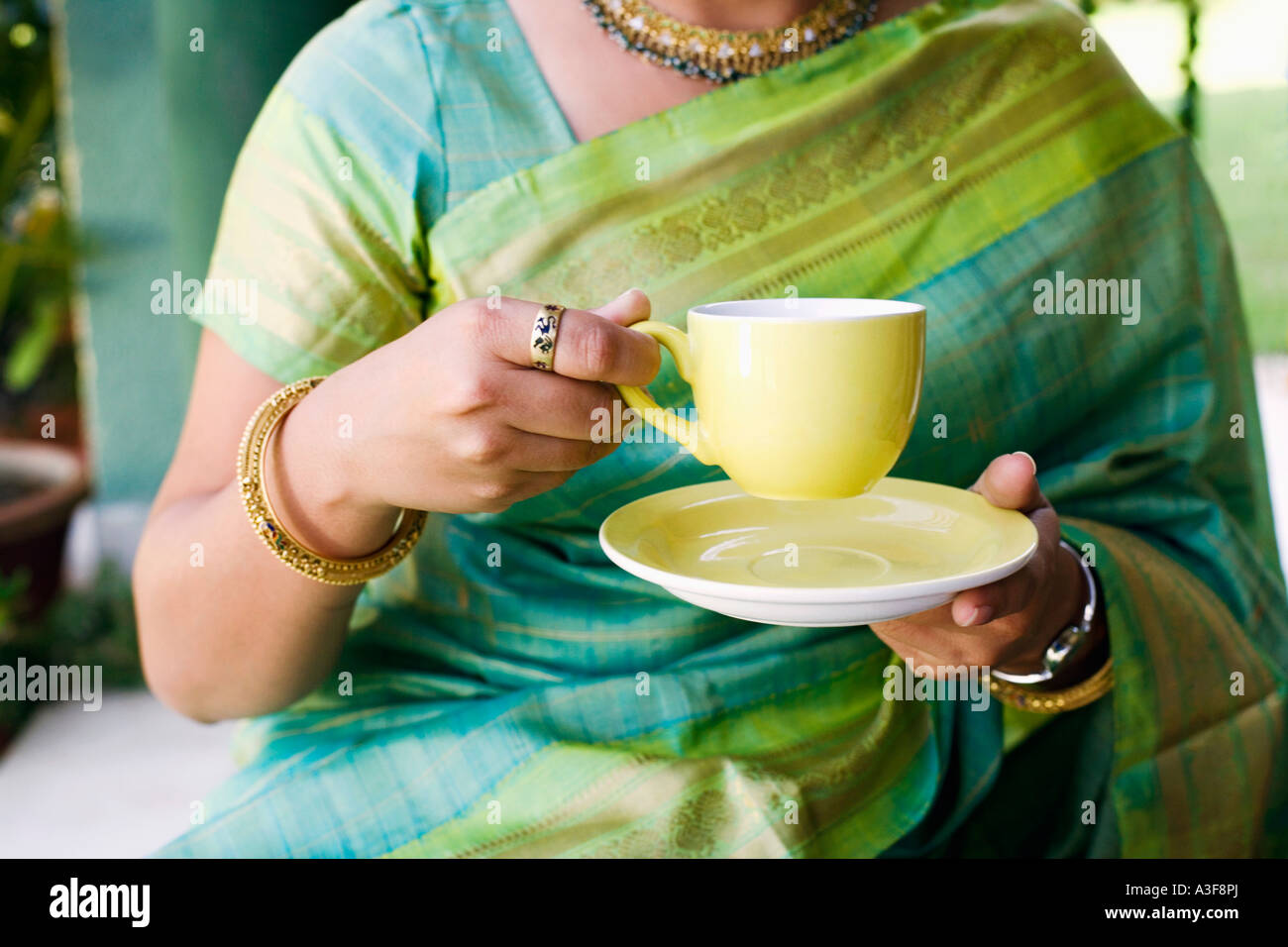 Mid section view of a young woman holding a cup of tea Stock Photo - Alamy
