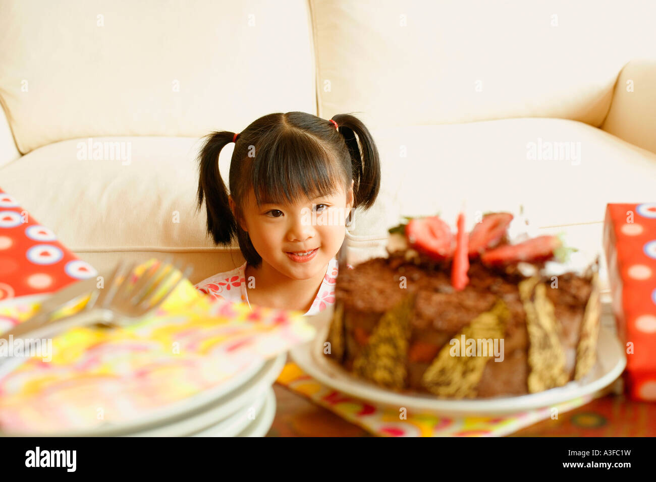 Girl smiling and looking at a cake Stock Photo - Alamy