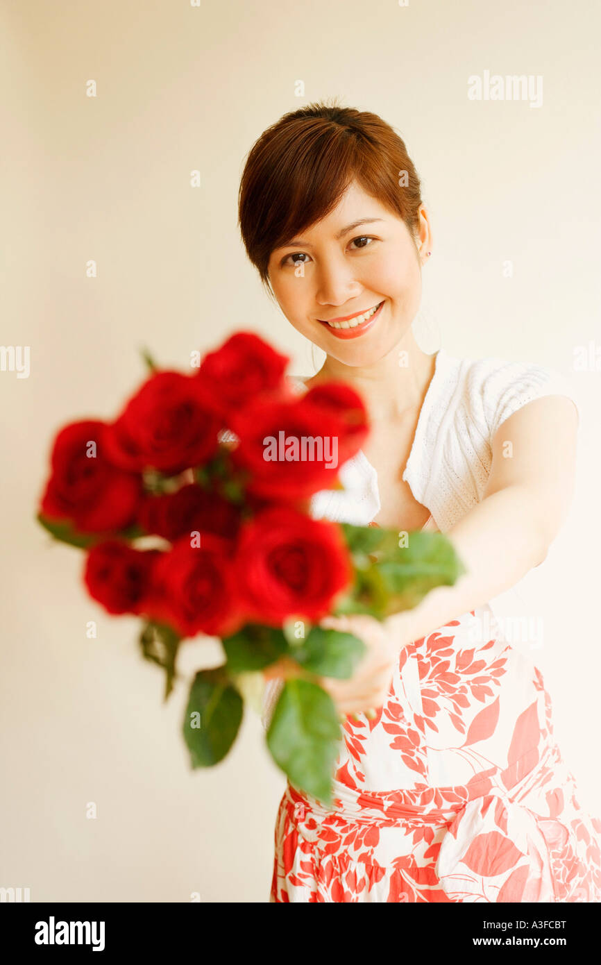 Portrait of a young woman holding a bunch of roses Stock Photo - Alamy
