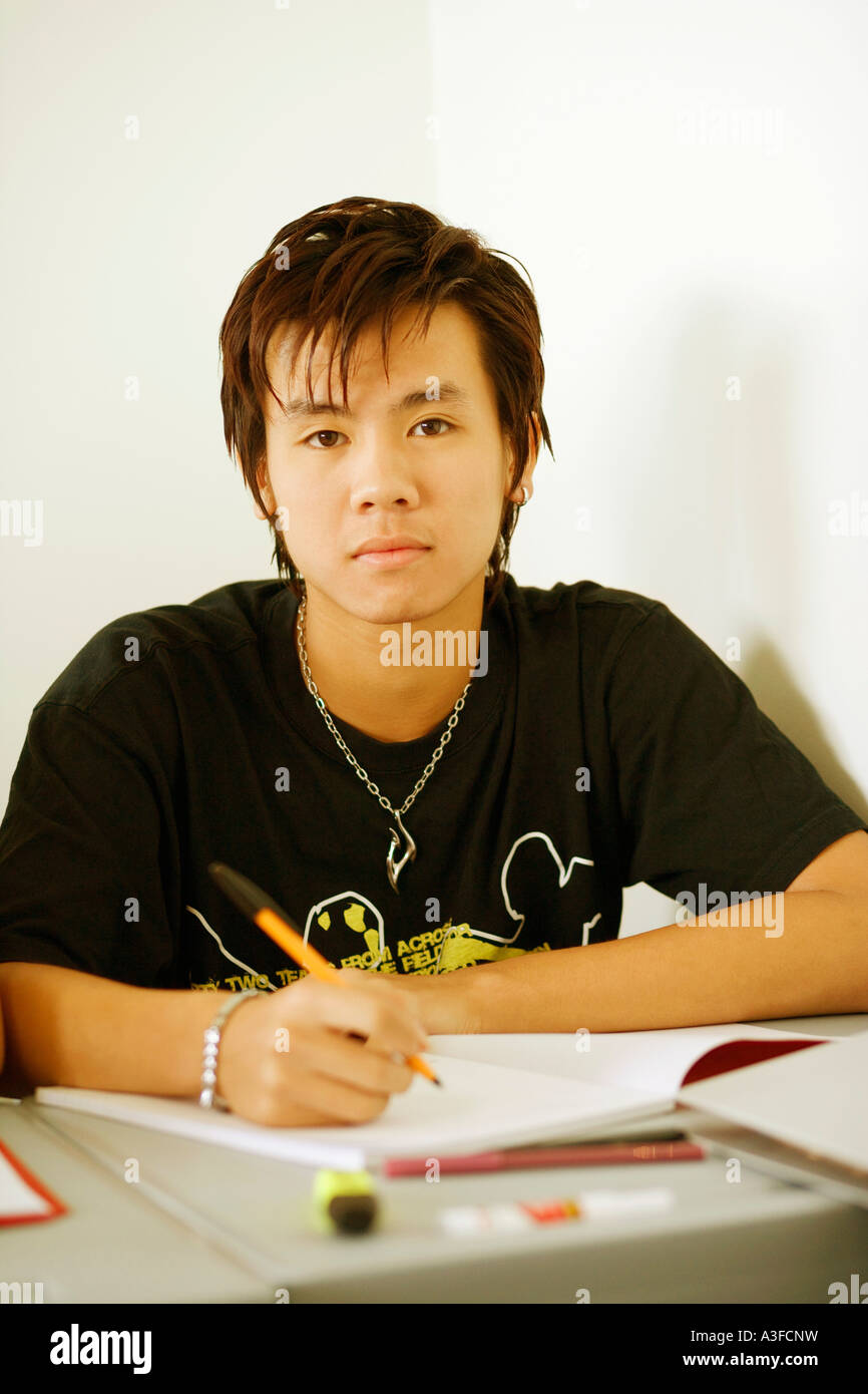 Portrait of a teenage boy holding a pen on a notepad Stock Photo - Alamy