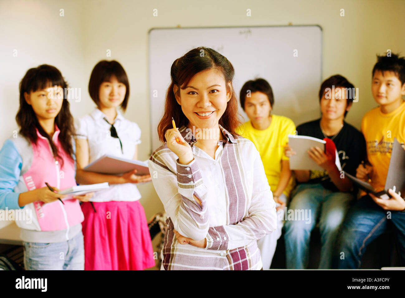 Portrait of a professor smiling with her students in a classroom Stock ...