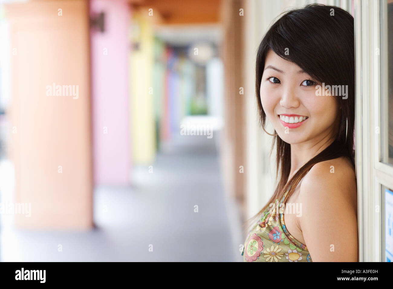 Portrait of a young woman leaning against a window Stock Photo - Alamy