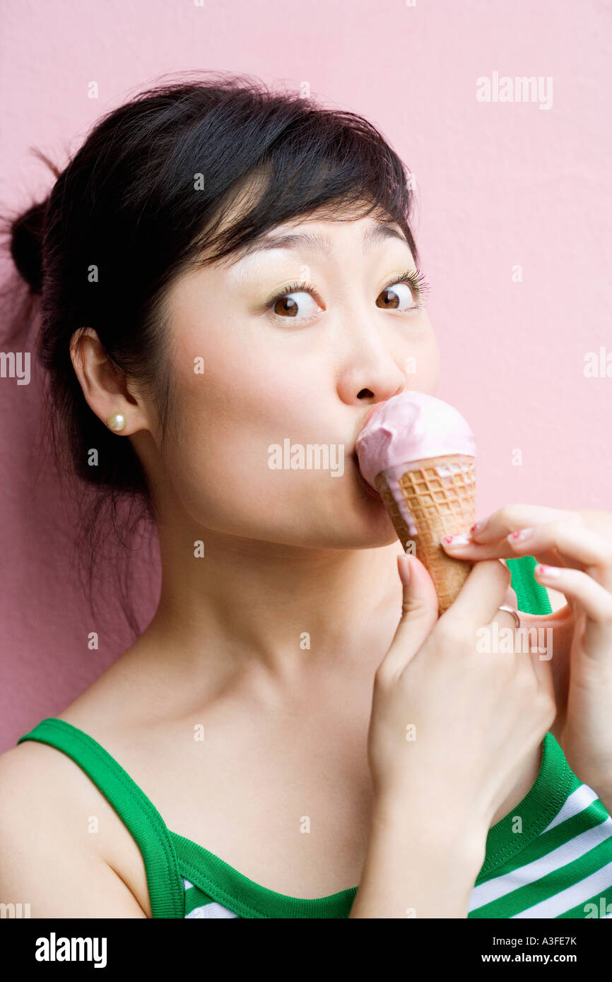 Close-up of a young woman eating an ice-cream cone Stock Photo - Alamy