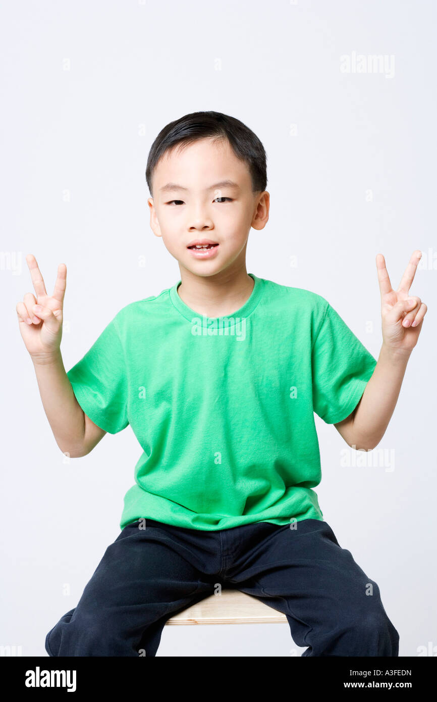 Portrait of a boy making a peace sign Stock Photo - Alamy