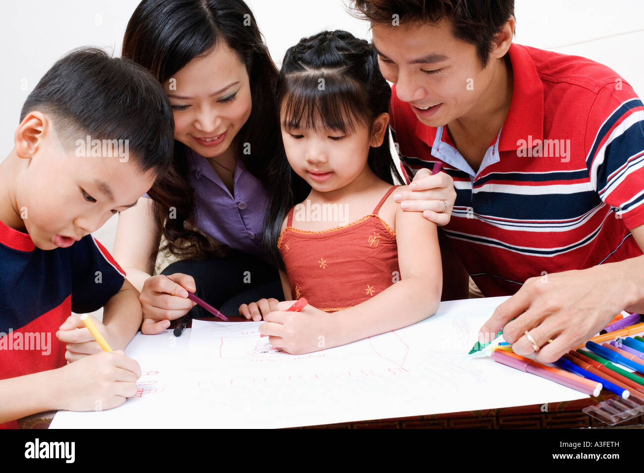 Close-up of parents drawing on paper with their children Stock Photo ...