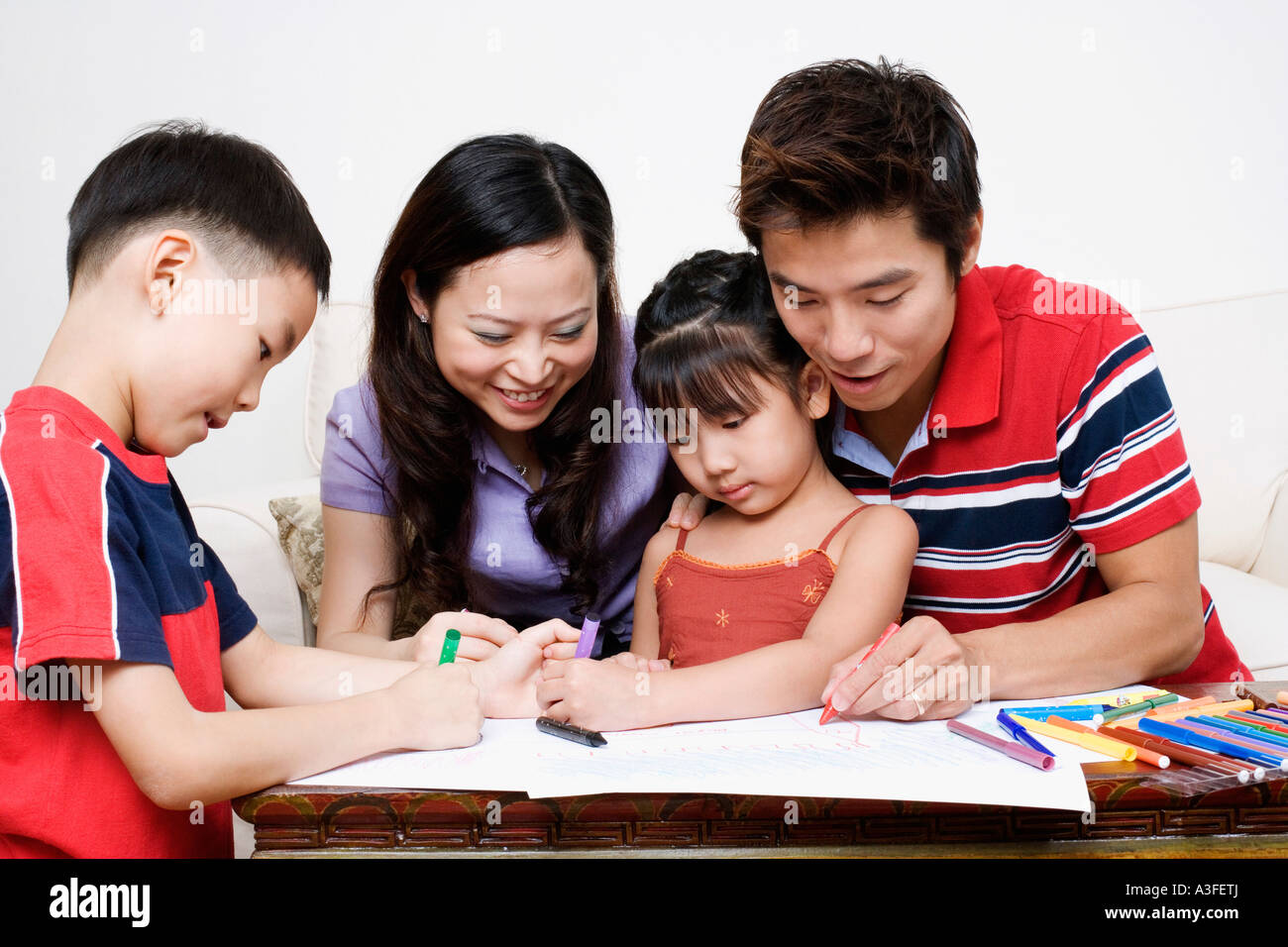 Close-up of parents drawing on paper with their children Stock Photo ...