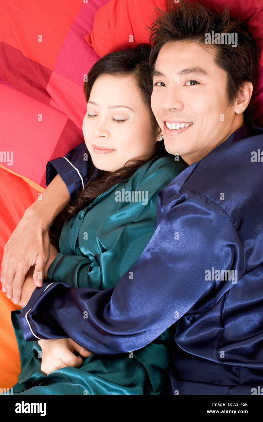Asian couple cuddling on bed hi-res stock photography and images - Alamy
