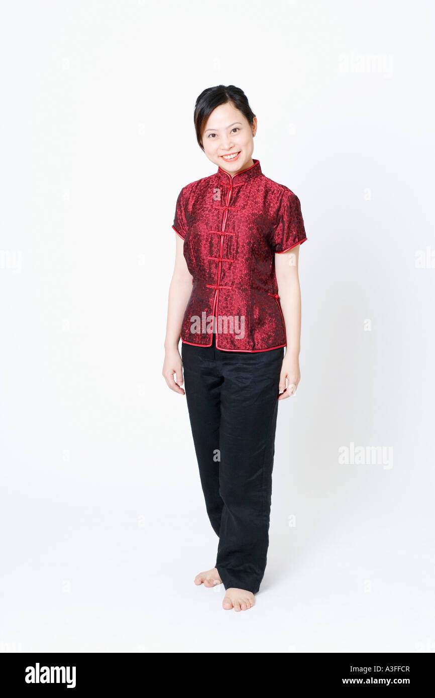 Portrait of a young woman standing and smiling Stock Photo - Alamy