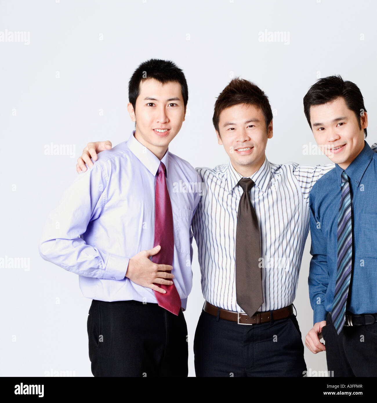 Portrait of three businessmen standing and smiling Stock Photo - Alamy
