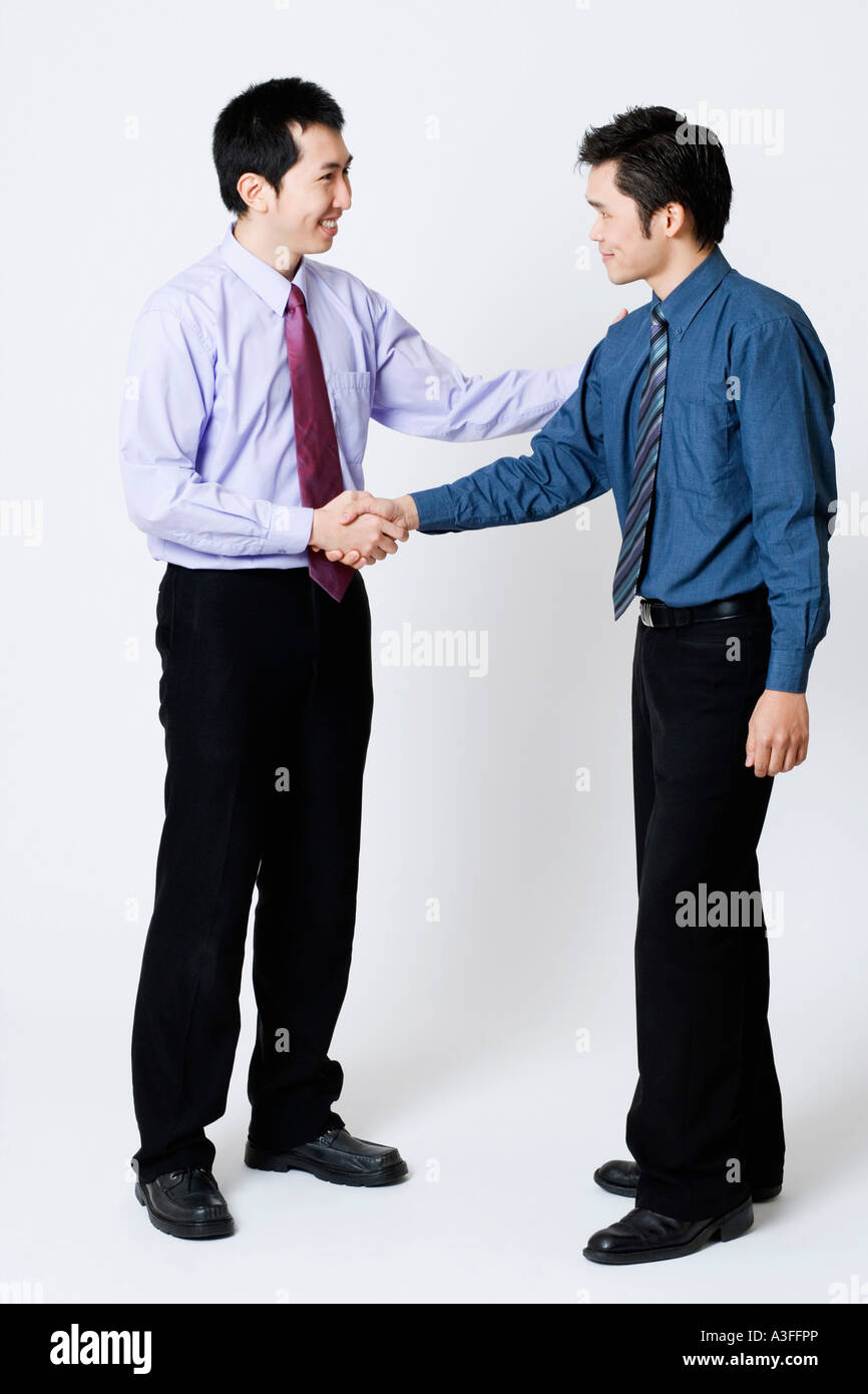 Two businessmen shaking hands Stock Photo - Alamy