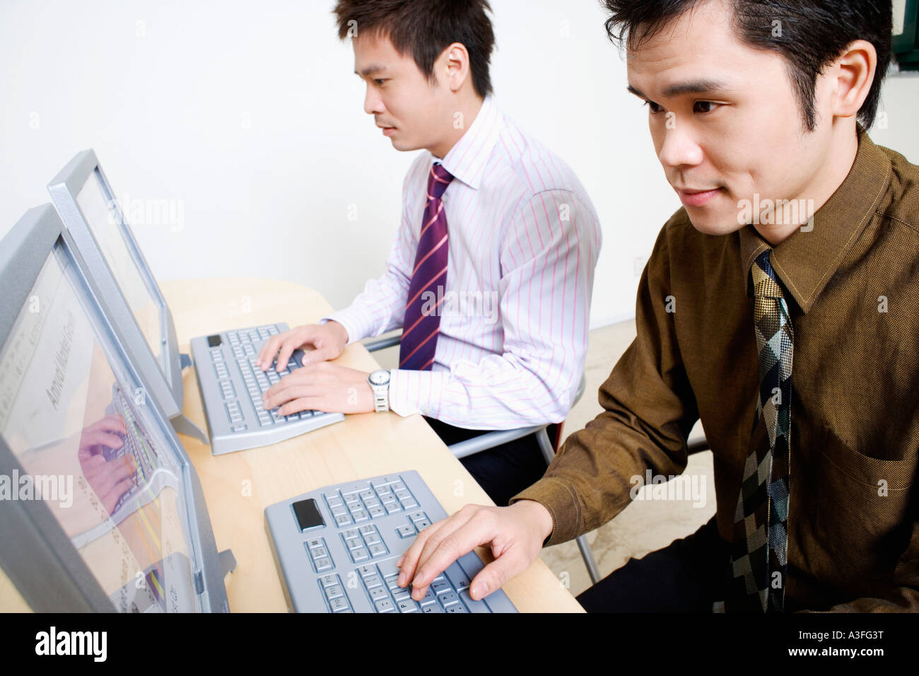 Two businessmen working on computers Stock Photo - Alamy
