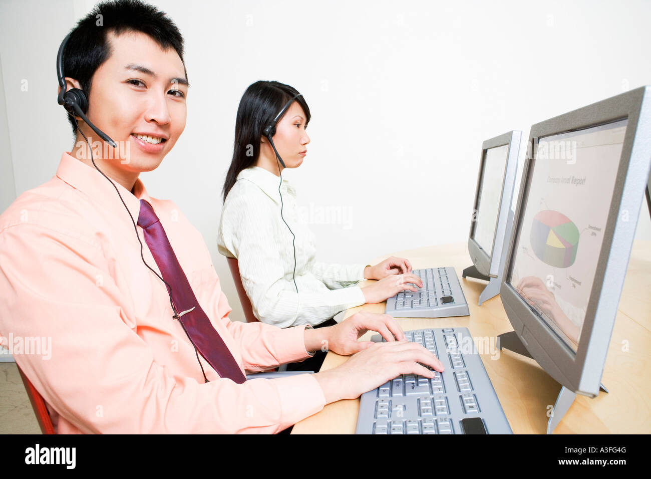 Two customer service representatives working on a computer Stock Photo ...