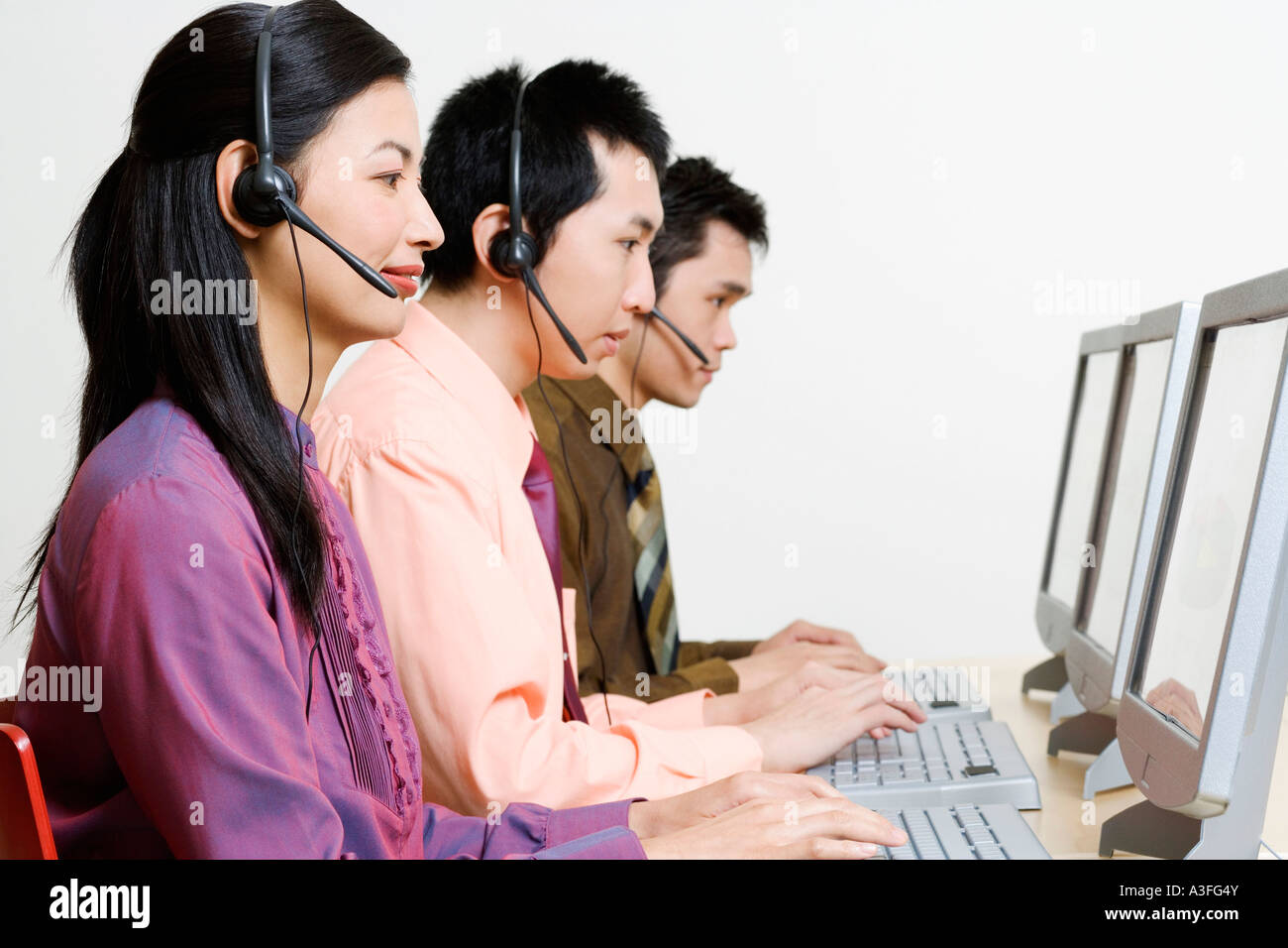 Three customer service representatives working on computers Stock Photo ...