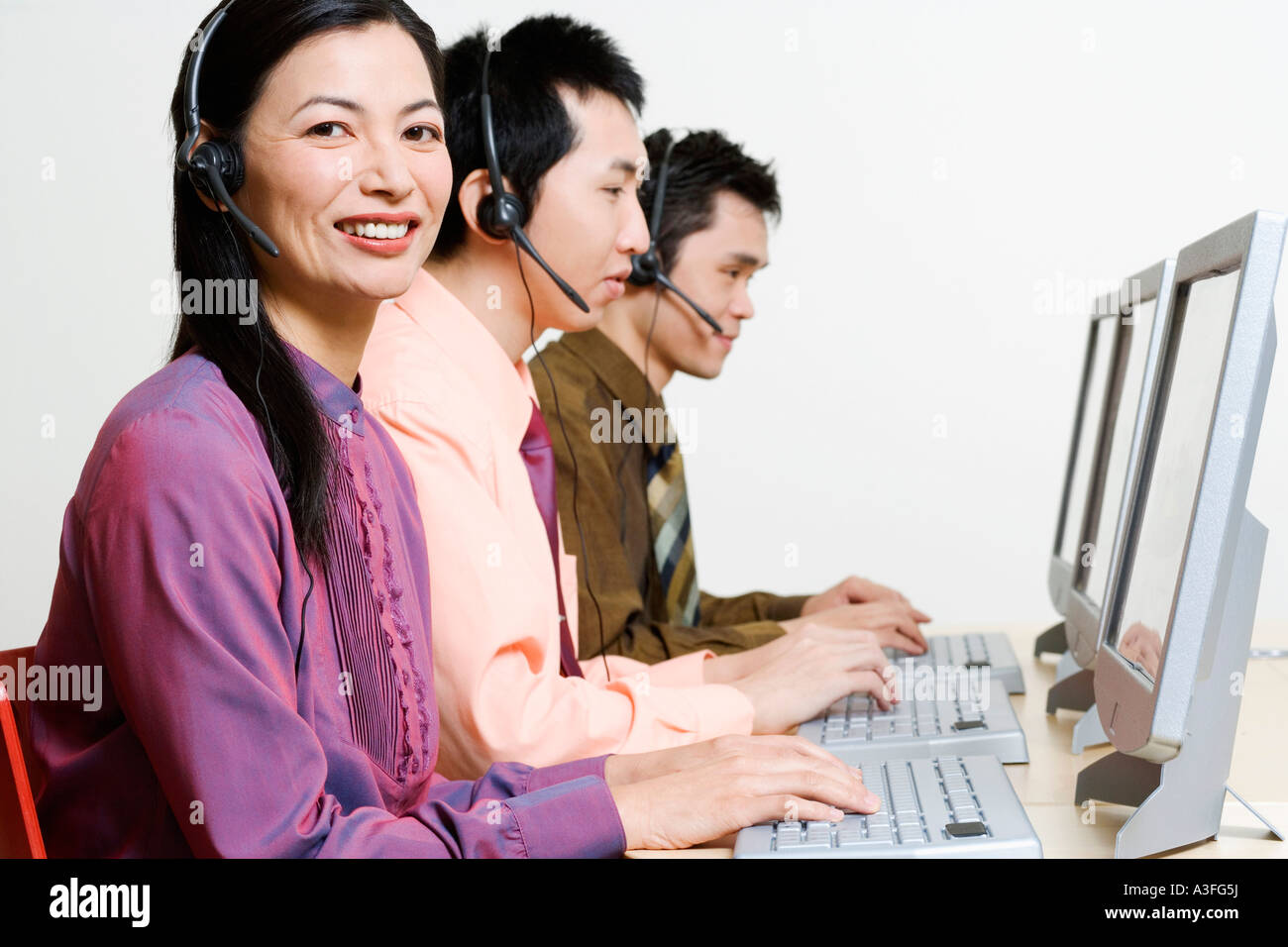 Three customer service representatives working on computers Stock Photo - Alamy