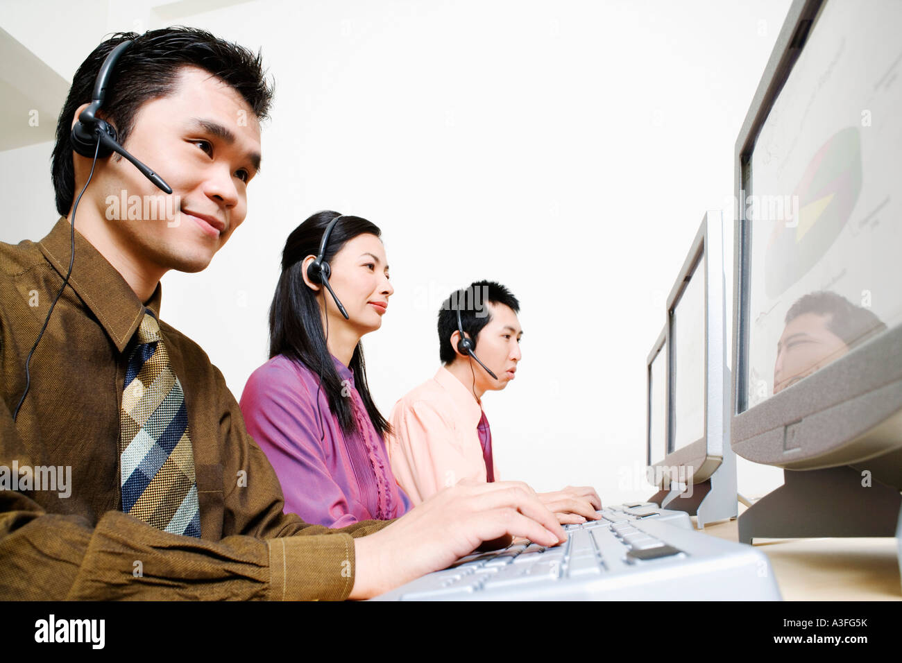 Three customer service representatives working on computers Stock Photo - Alamy