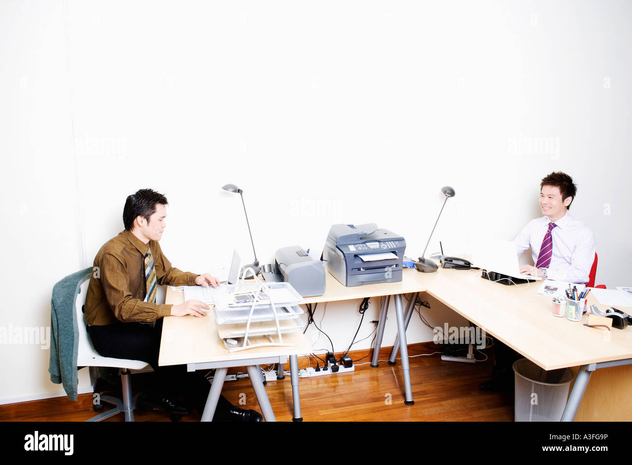Two businessmen sitting face to face Stock Photo - Alamy