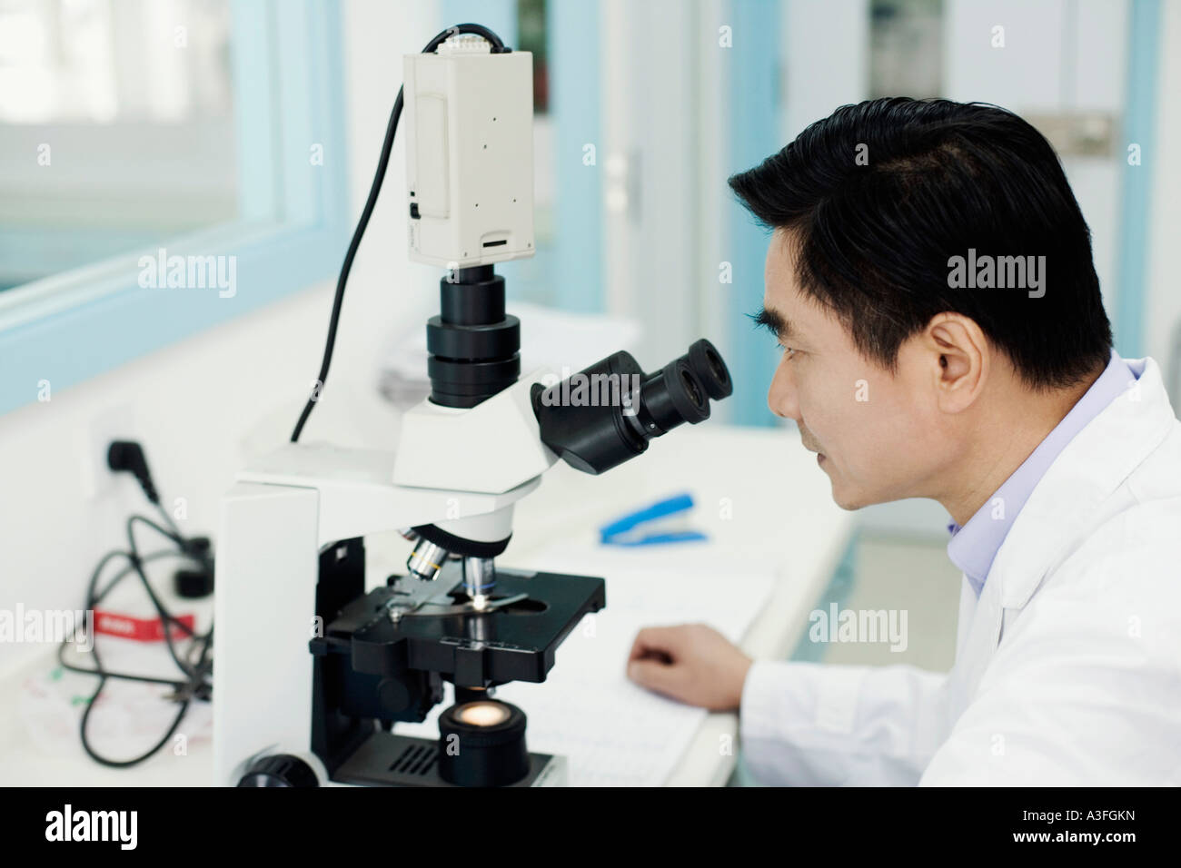 Black man looking through microscope hi-res stock photography and ...