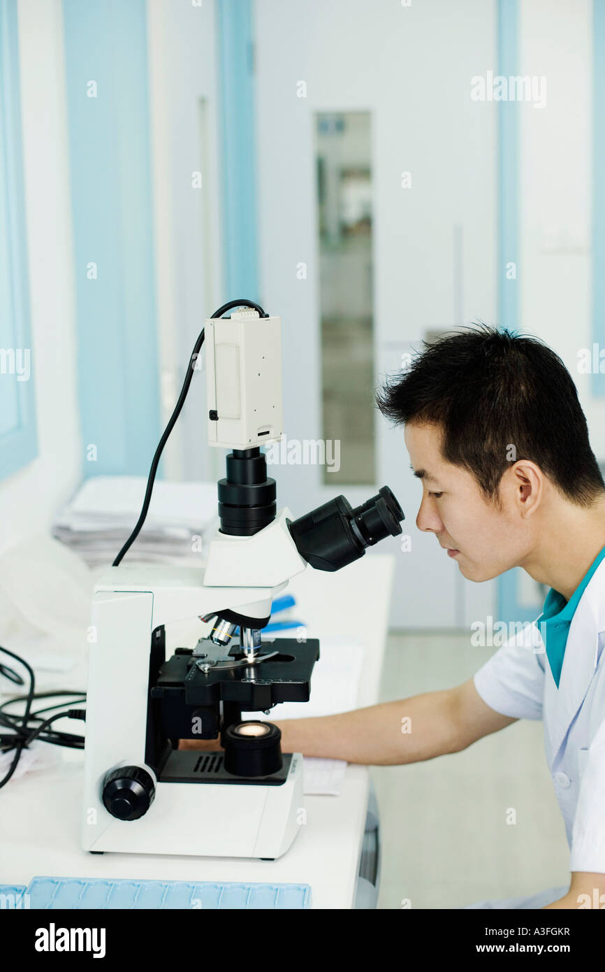 Black man looking through microscope hi-res stock photography and ...