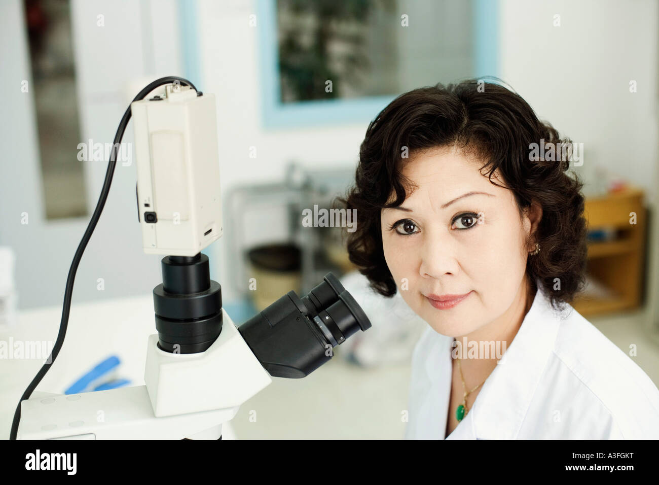 Portrait of a female doctor in front of a microscope Stock Photo - Alamy