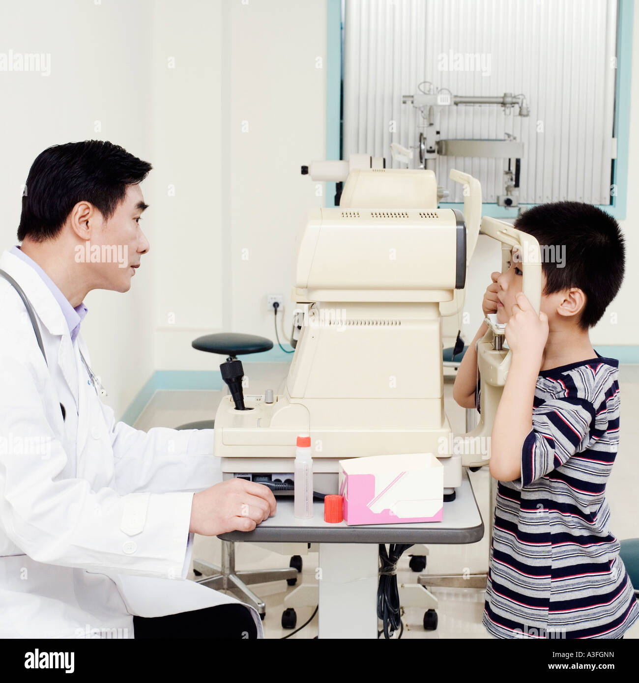 Side profile of an optometrist examining a patient Stock Photo - Alamy