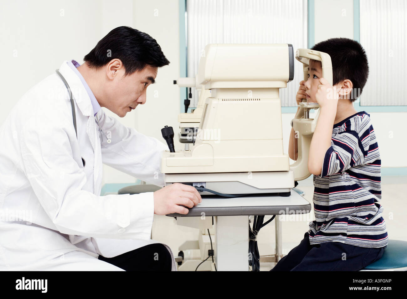 Side profile of an optometrist examining a patient Stock Photo - Alamy