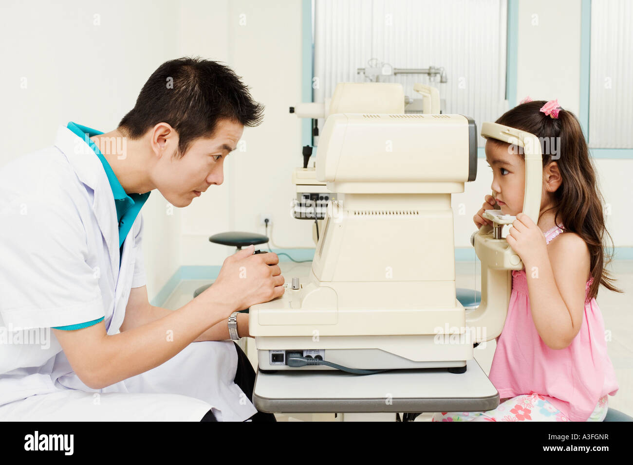 Side profile of an optometrist examining a patient Stock Photo - Alamy