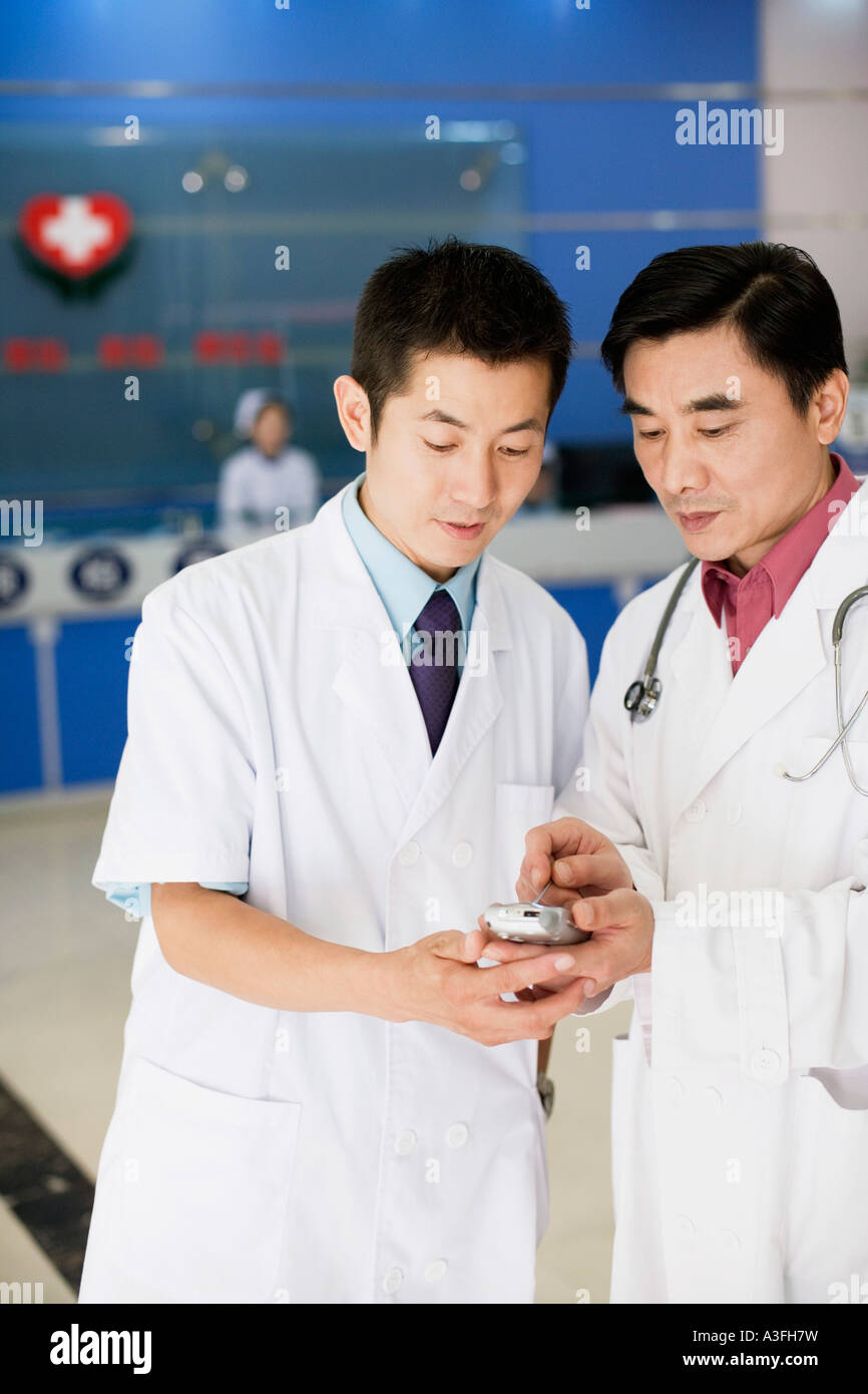 Close-up of two male doctors looking at a personal data assistant Stock ...