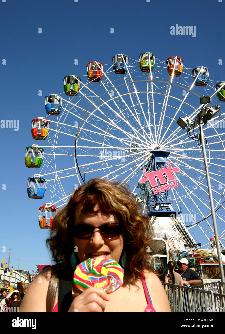 LADY WITH LOLLIPOP IN FRONT OF FERRIS WHEEL VERTICAL BAPDB9035 Stock ...
