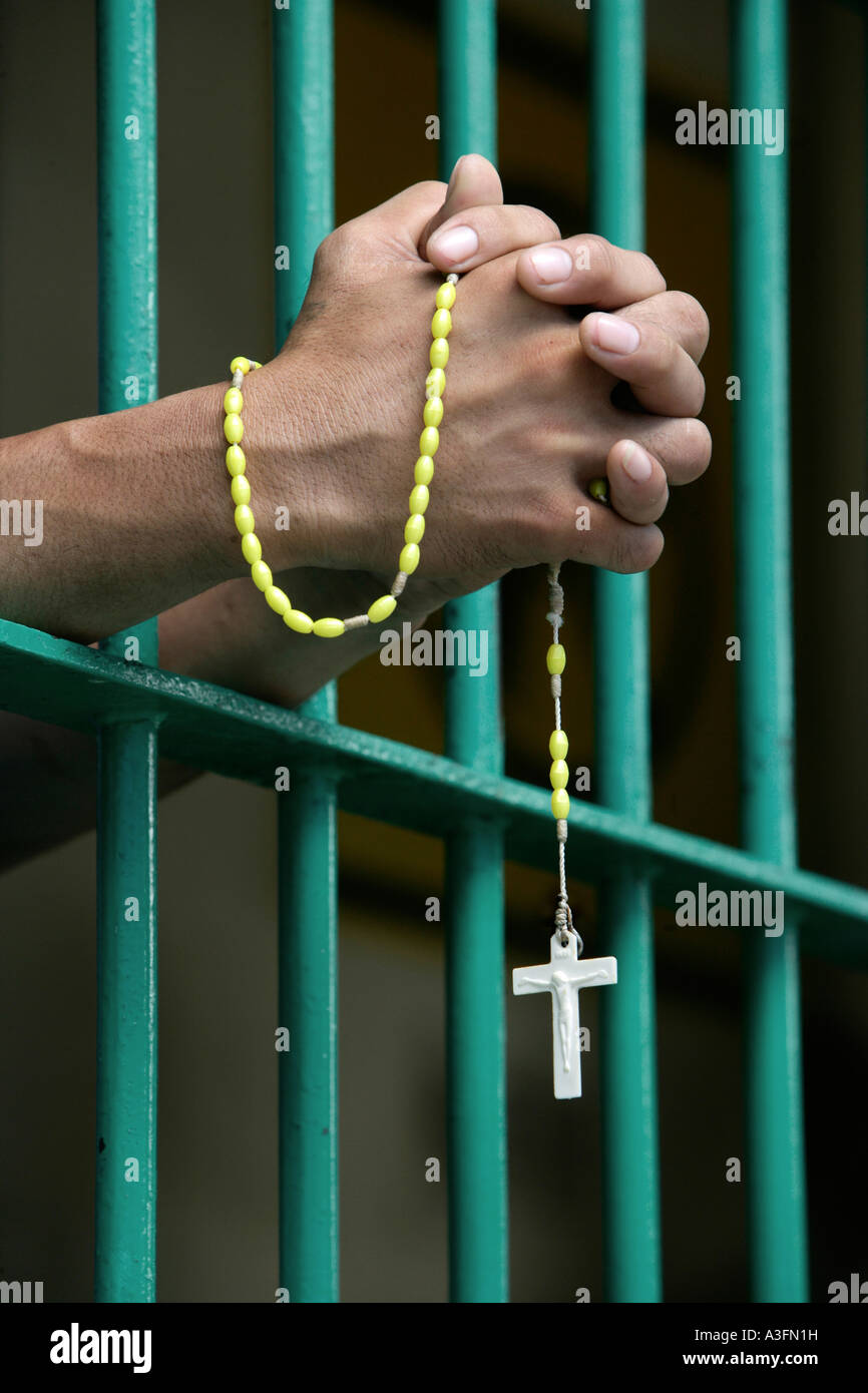 The Philippines, Prisoner behind bars praying the rosary Stock Photo ...