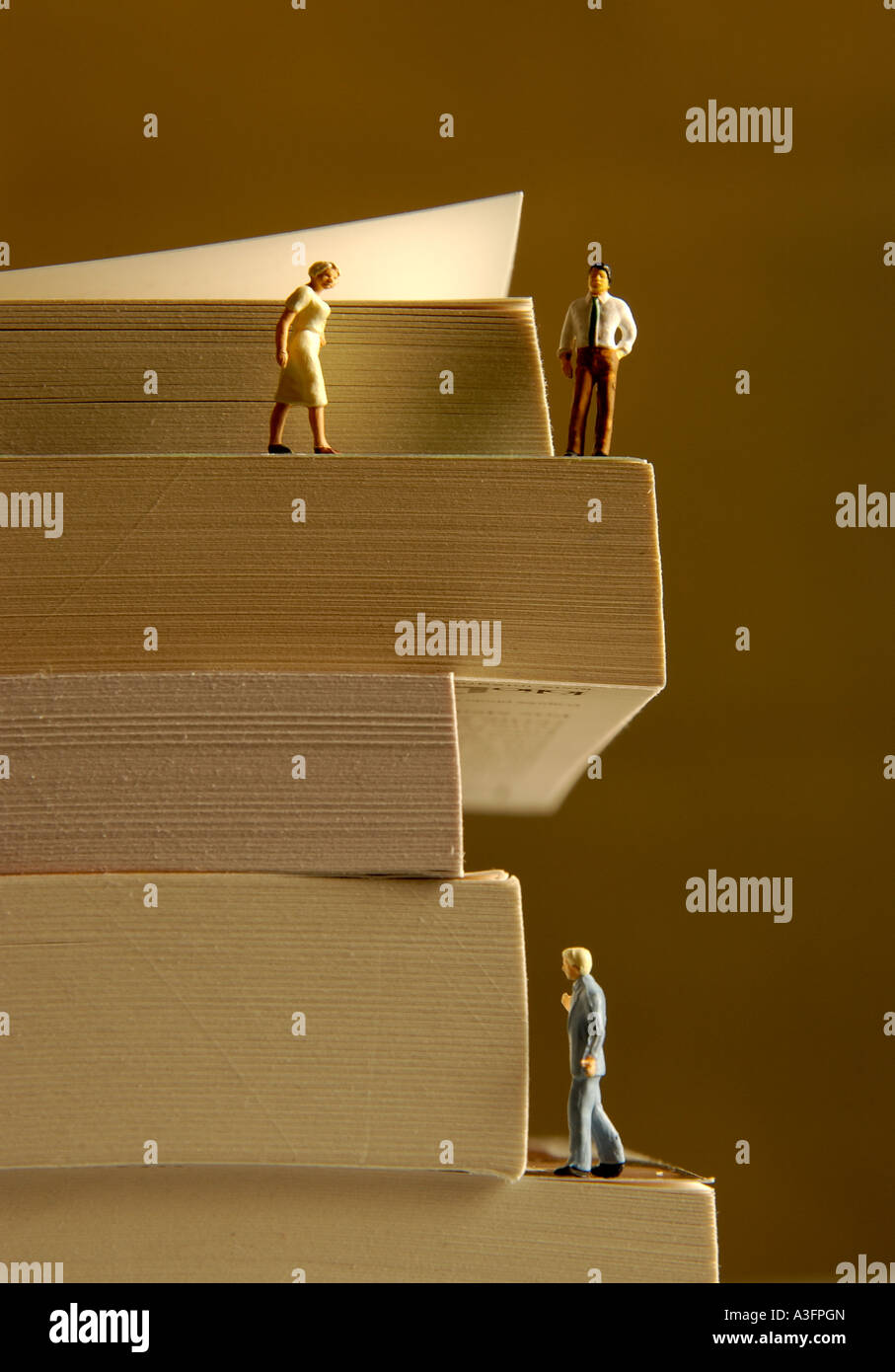 Figurines shaking hands on pile of books Stock Photo - Alamy